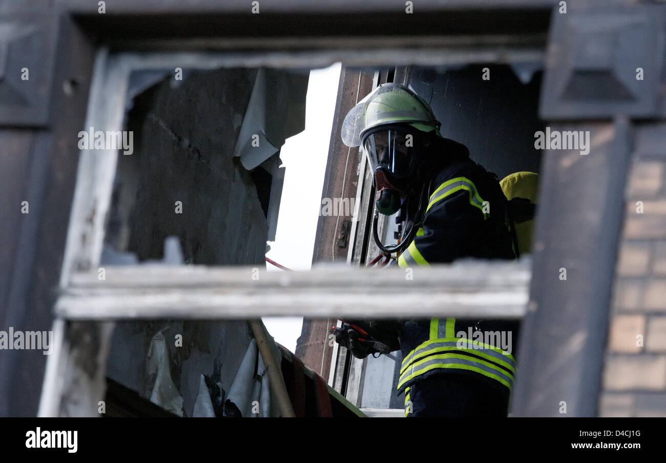 A firefighter stands inside a flat of a burnt out residential house in ...