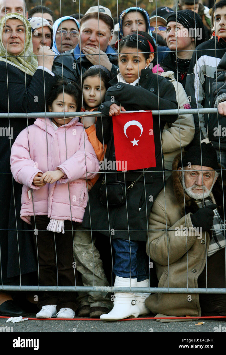 Mourning people of Turkish descent stand at a fence in front of the ...