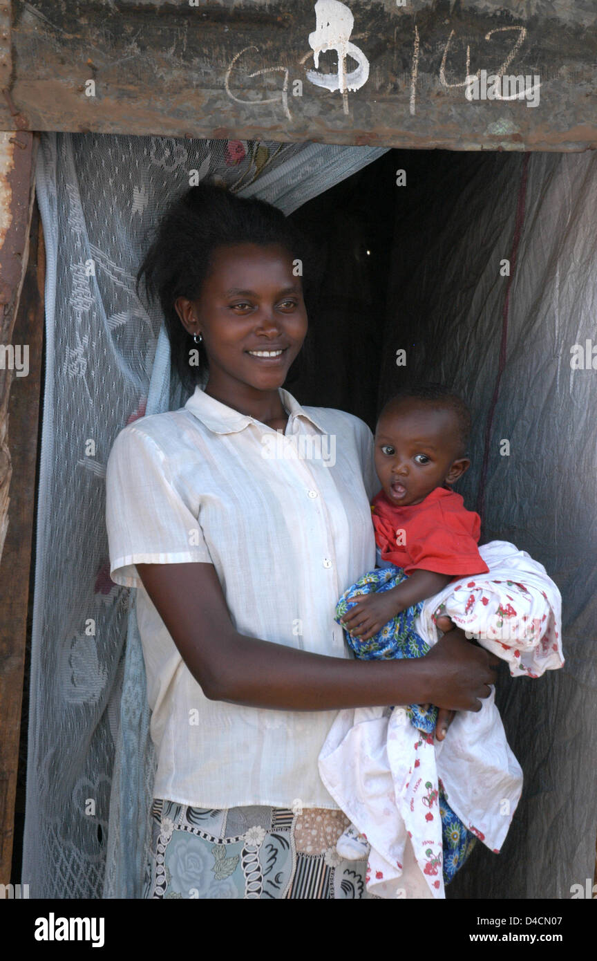 A single mother with her child stands outside their hut in the Huruma ...