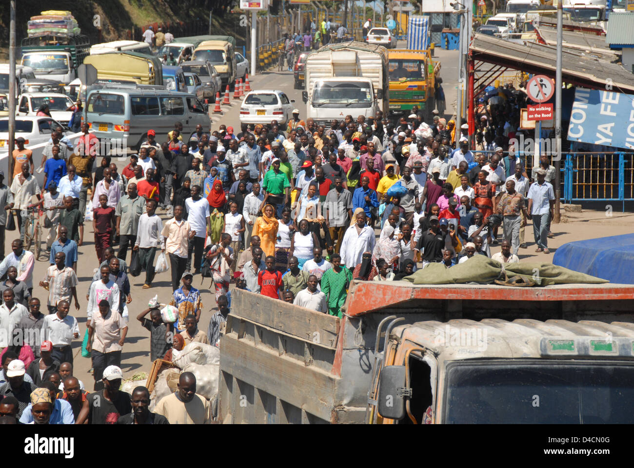 The picture shows a crowd of people on their way to board a ferry in ...