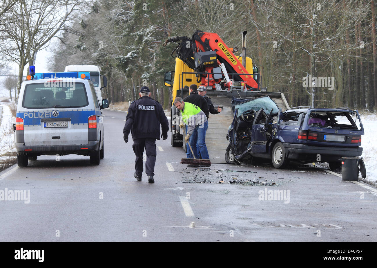 A police officer looks at a damaged car at highway 188 in Gardelegen ...