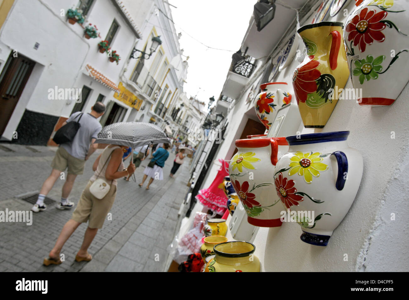 Tourists are pictured in a shopping street in the resort town of Nerja ...