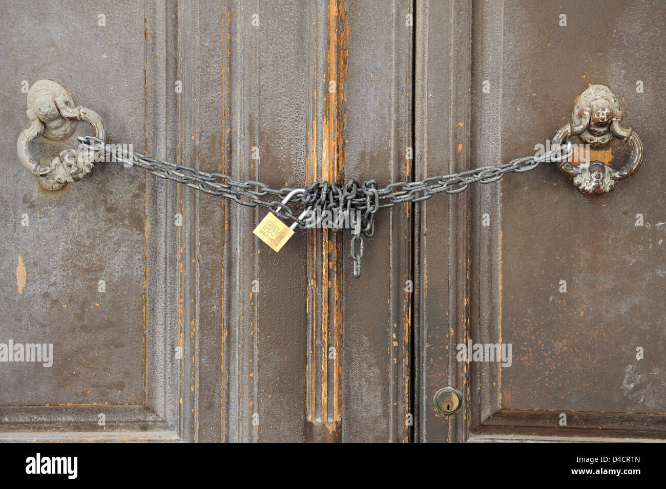 A door is locked with a chain and a padlock in the city of Malaga ...