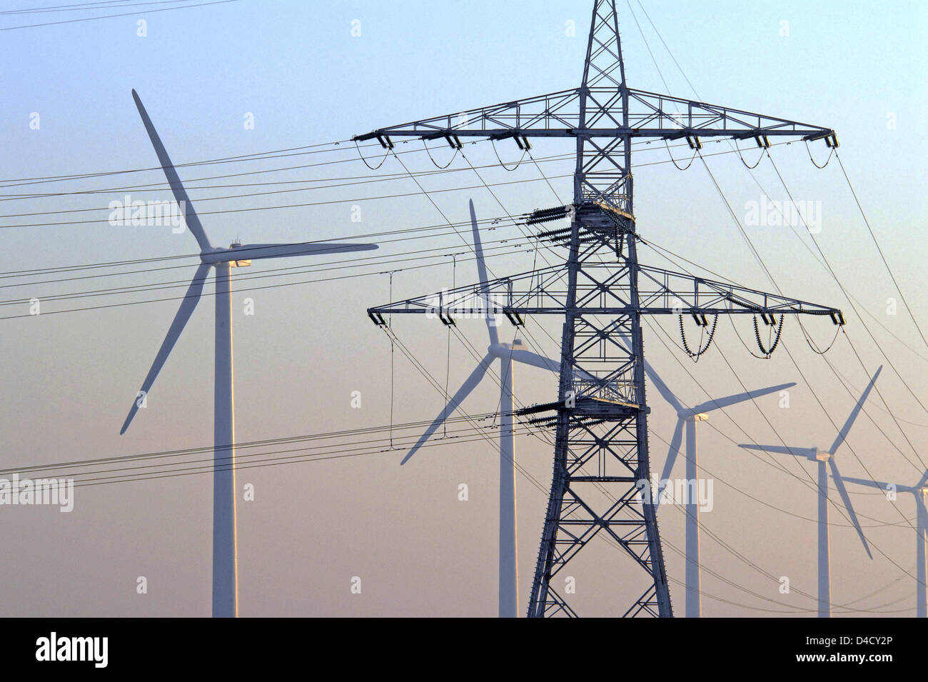 A power pylon and wind turbines are pictured at dusk near Stade ...