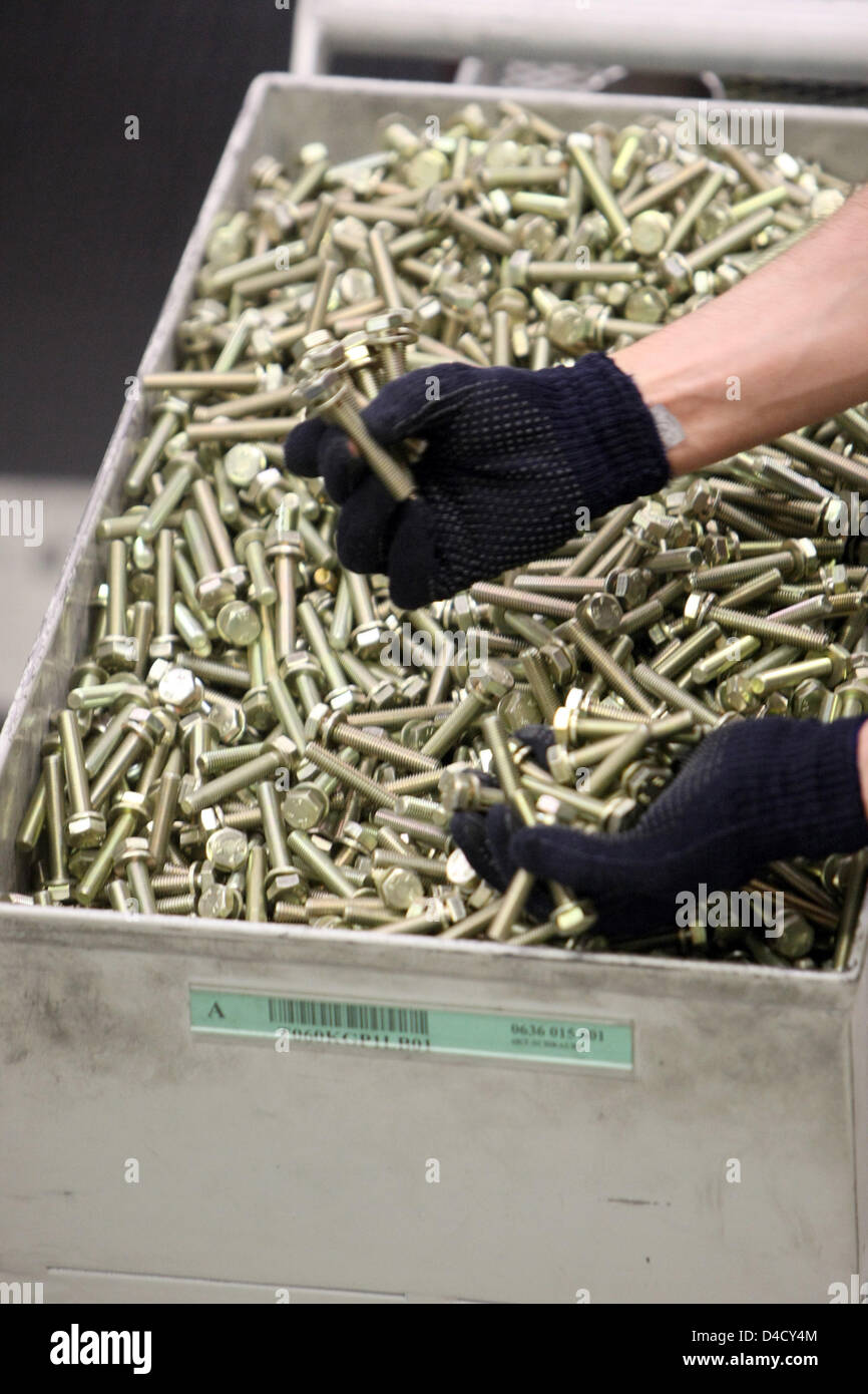An emloyee of ZF picks screws from a box in Friedrichshafen, Germany ...