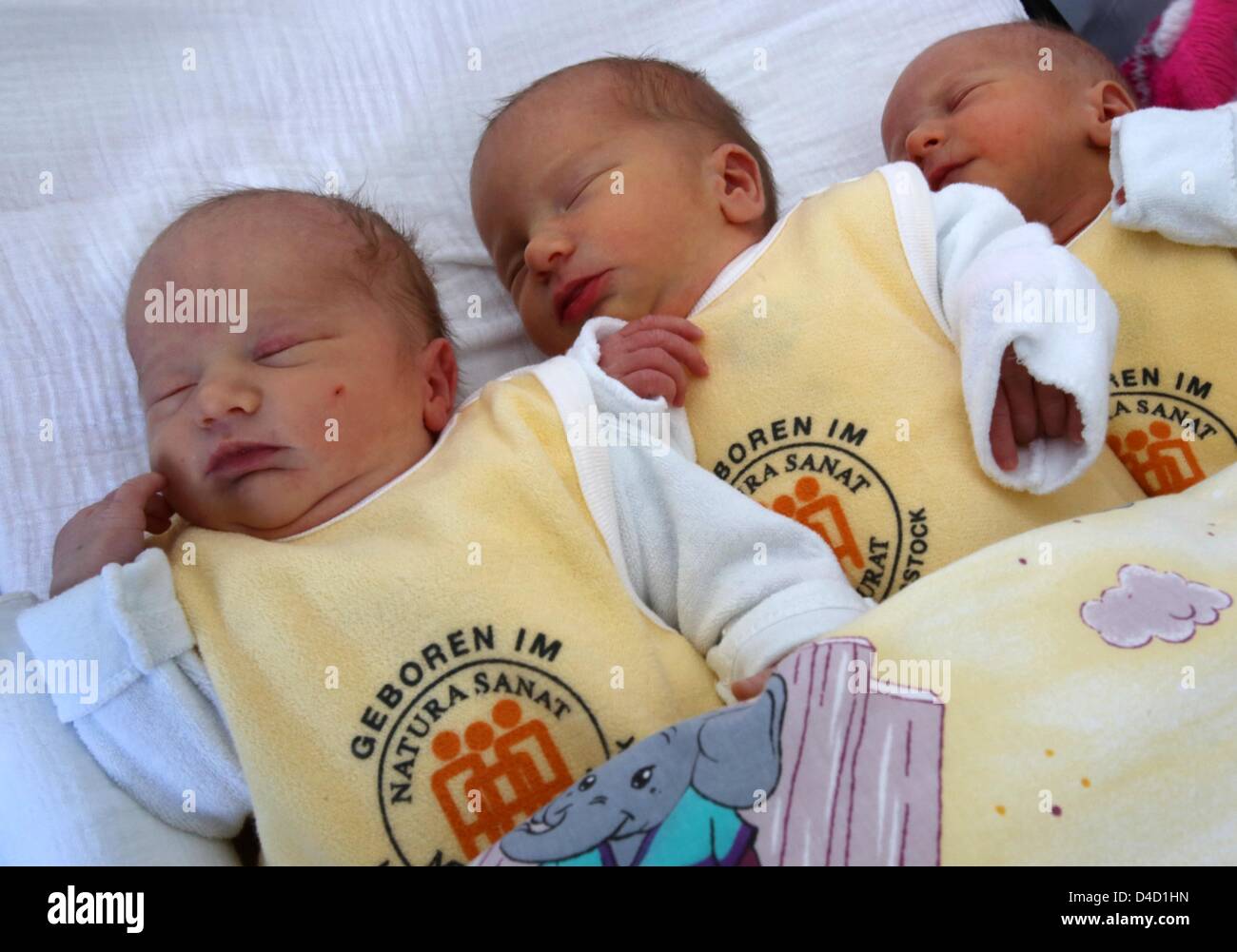 Triplets Emma (L-R), Hermine and Ben sleep in their bed at ...