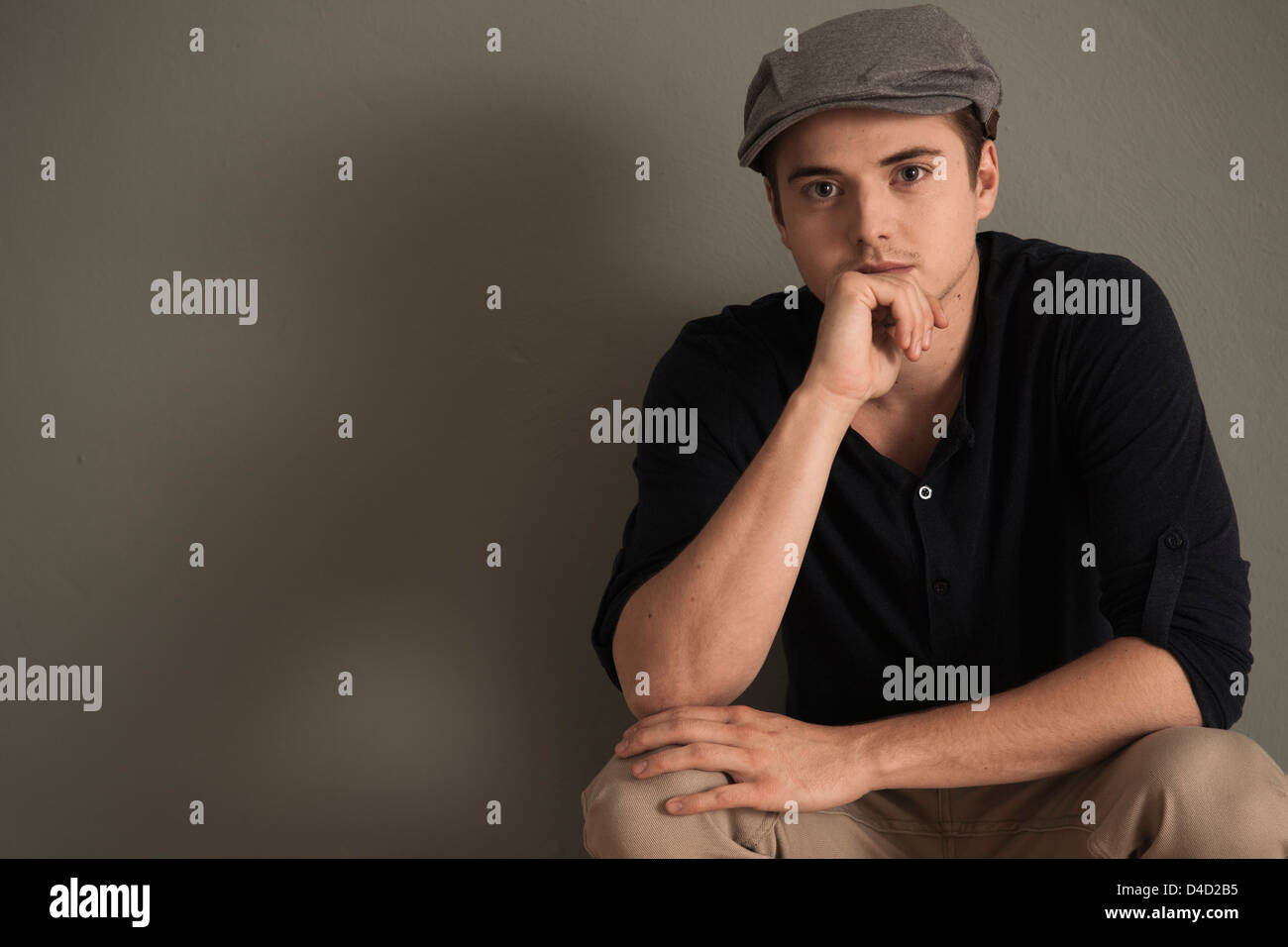 Thoughtful young man wearing cap Stock Photo - Alamy