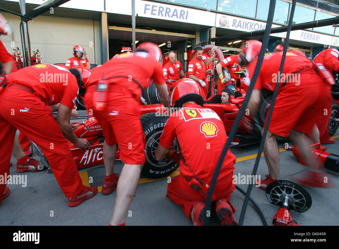 Mechanics of the Ferrari team practice for the pit stop at the pit lane ...