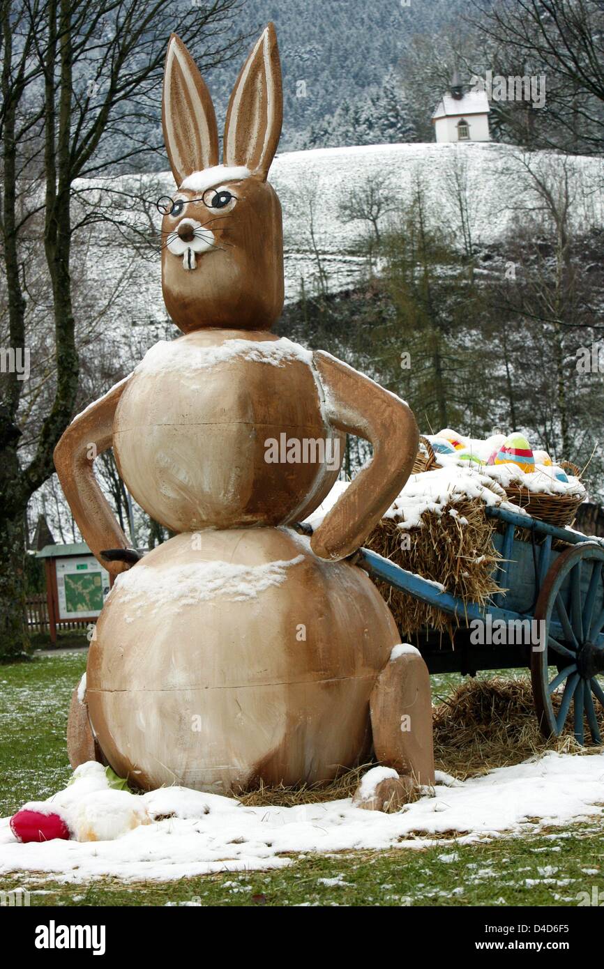 A cardboard Easter bunny is covered with a little bit of snow at Easter ...