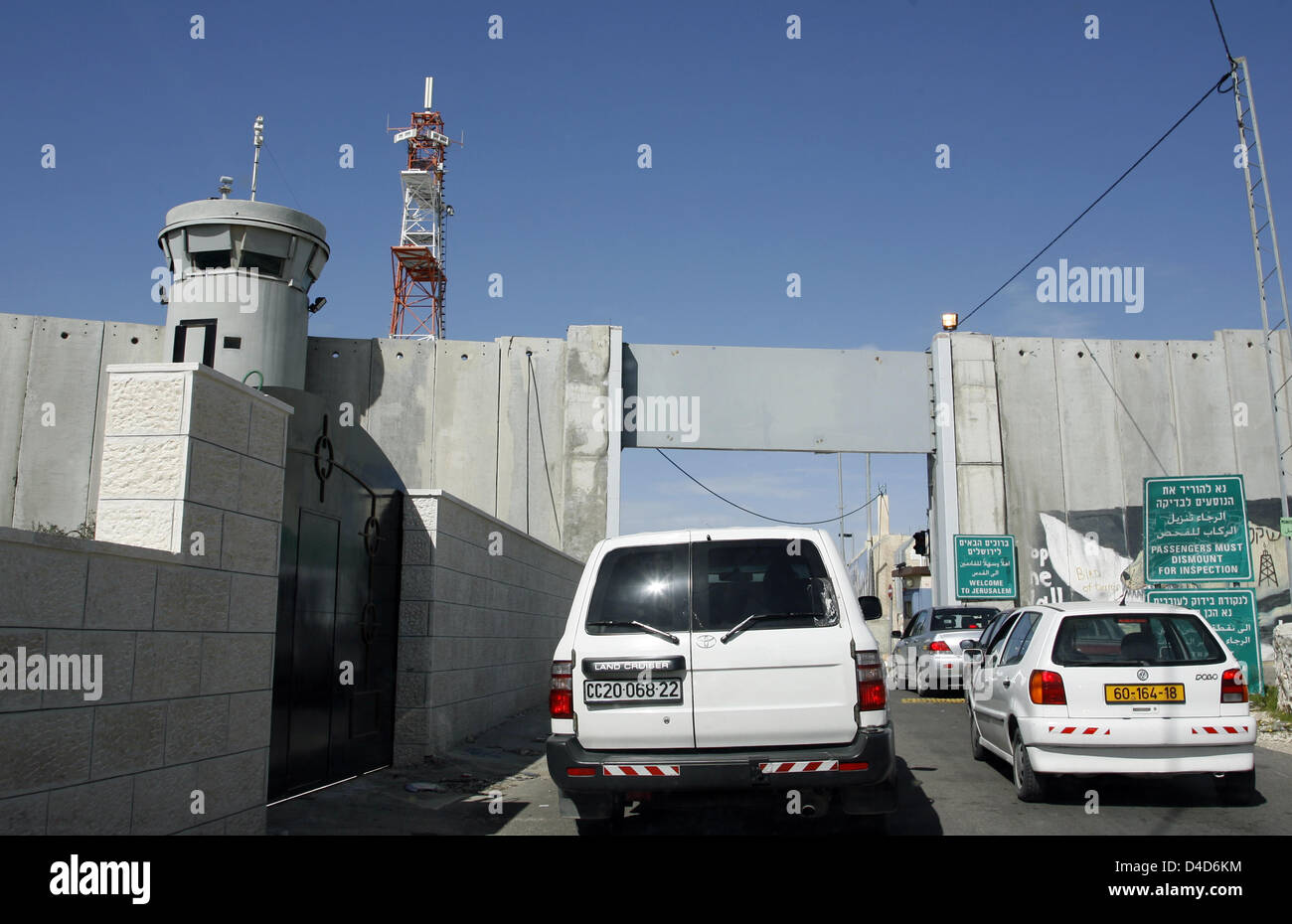 Car wait in front of a gate of the Israeli security wall separating ...
