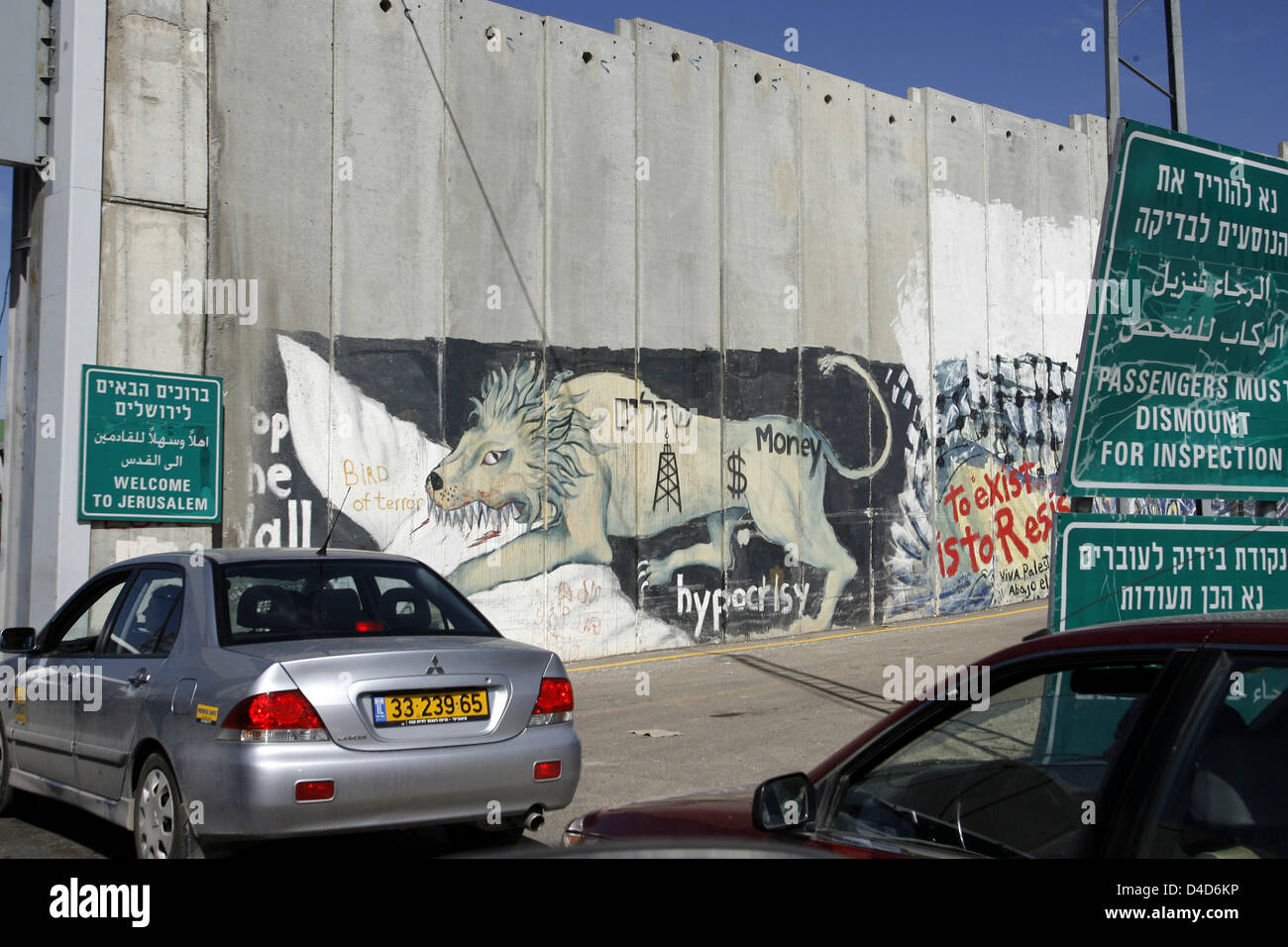 Car wait in front of a gate of the Israeli security wall separating ...