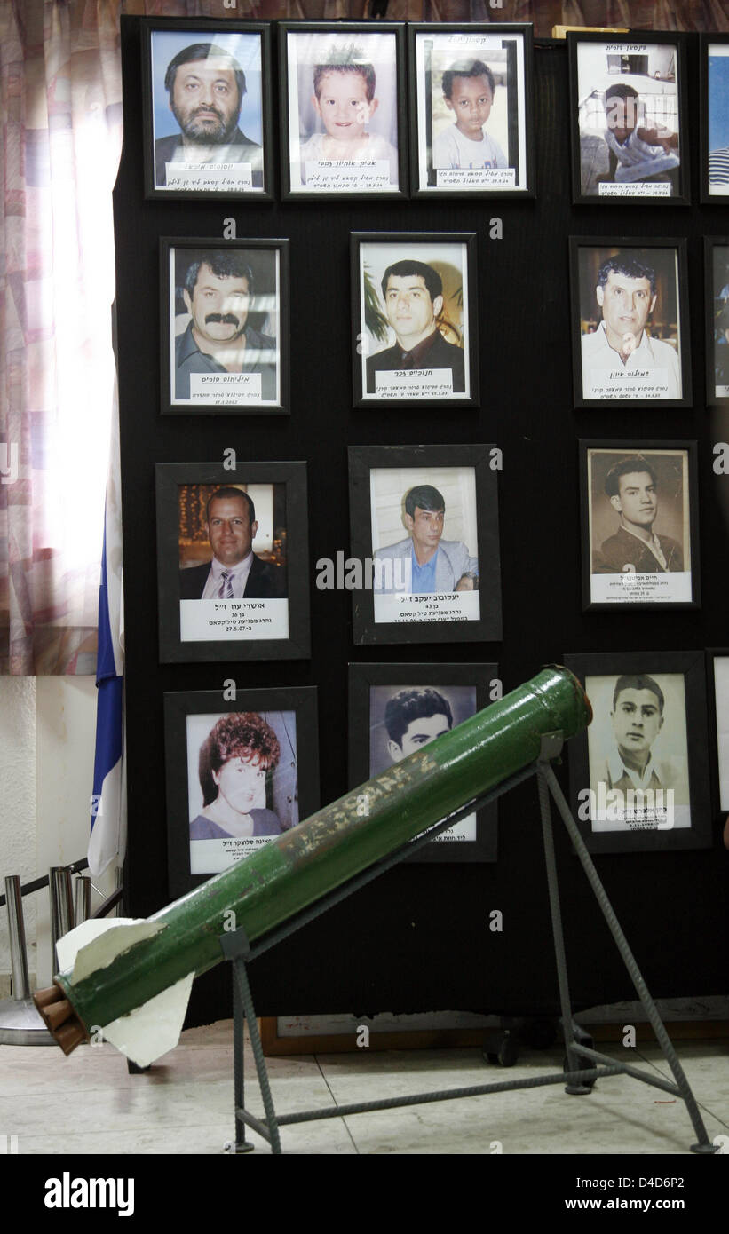 A model of a Qassam rocket stands in front of pictures of inhabitant ...