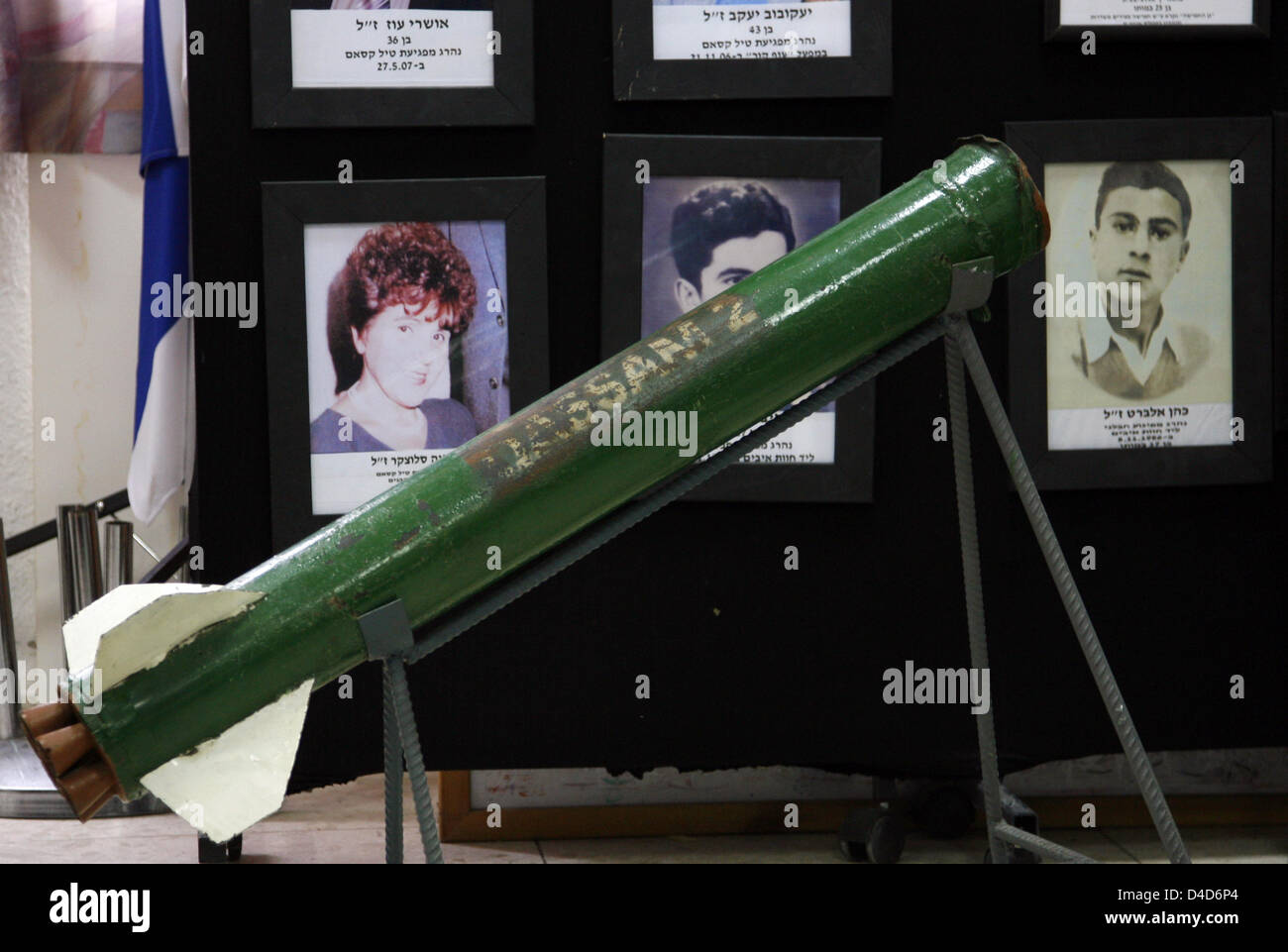 A model of a Qassam rocket stands in front of pictures of inhabitant ...