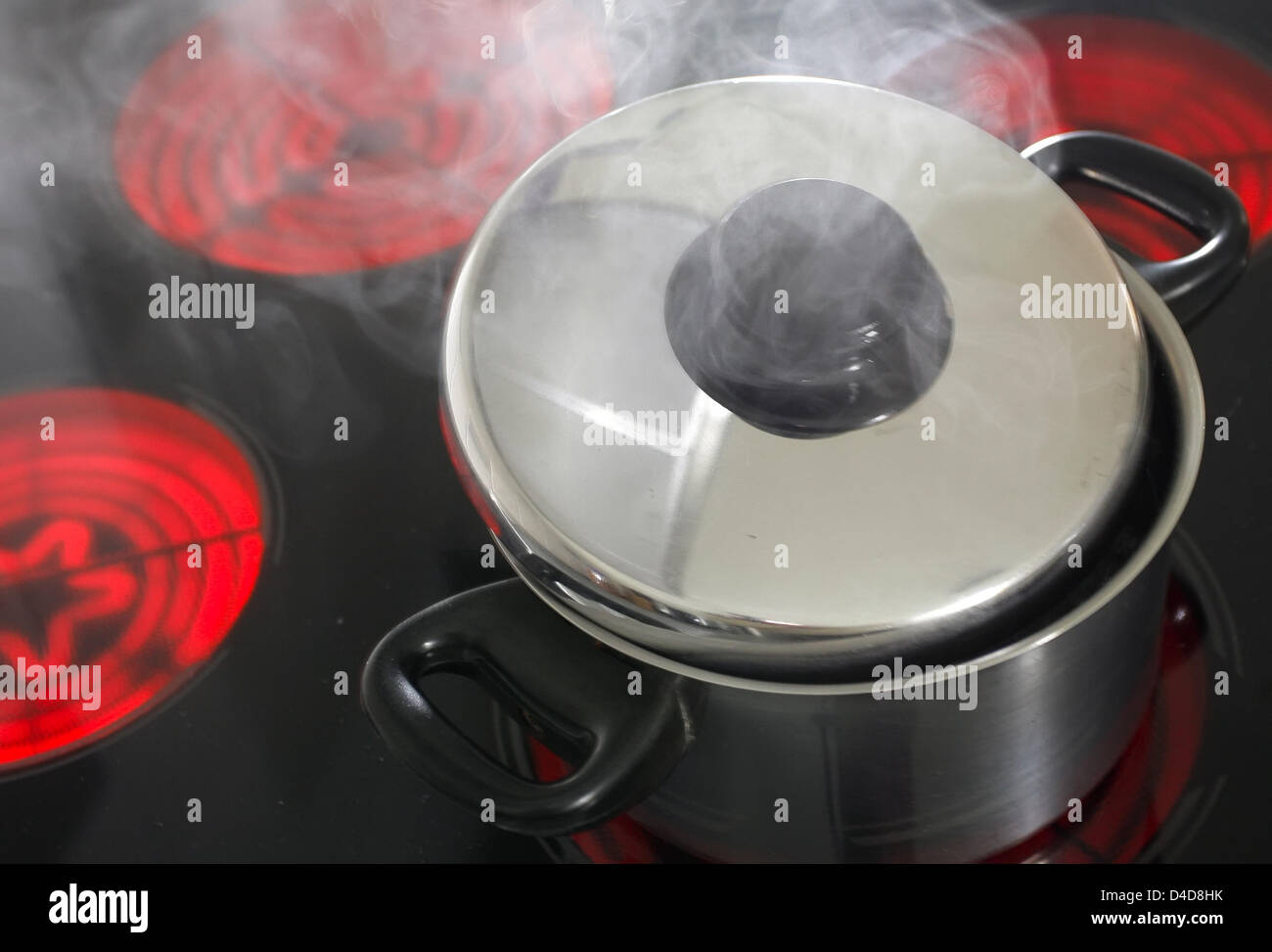The picture shows a steaming cooking pot on an electric cooker in ...