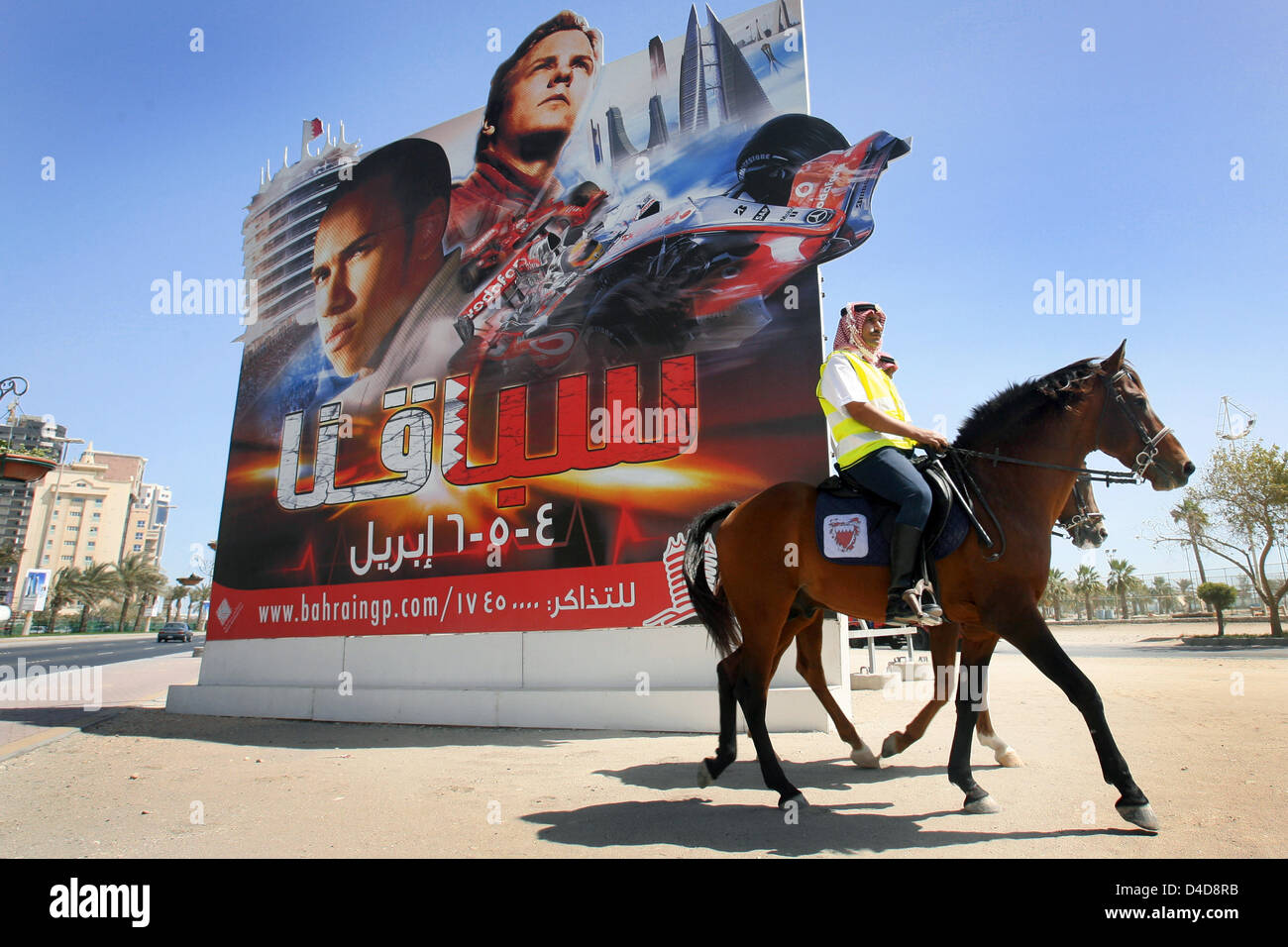 Bahrain policemen patrol on their horses in front of a giant banner of ...