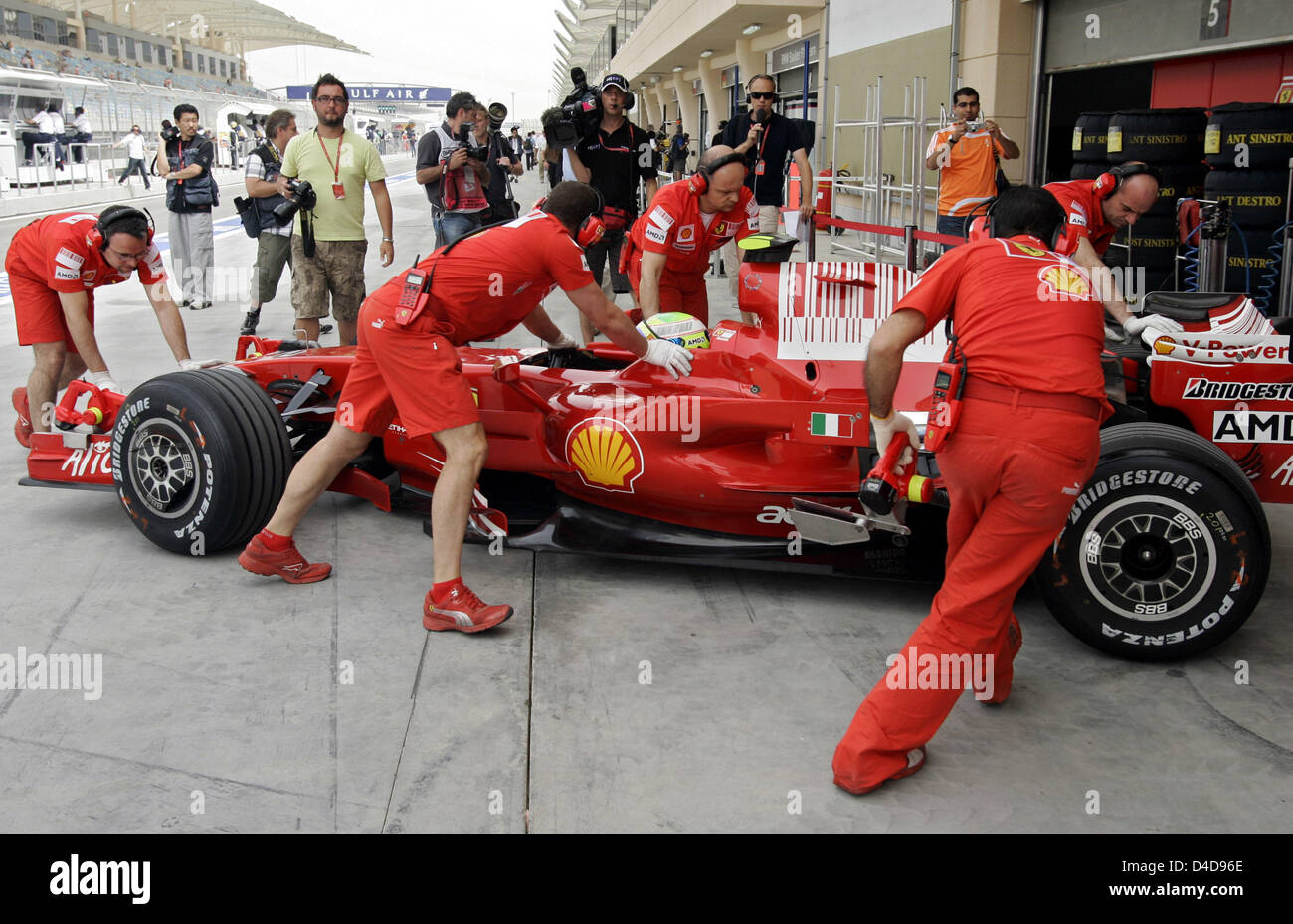 Mechanics of Ferrari push back the racing car of Brazilian Formula One ...