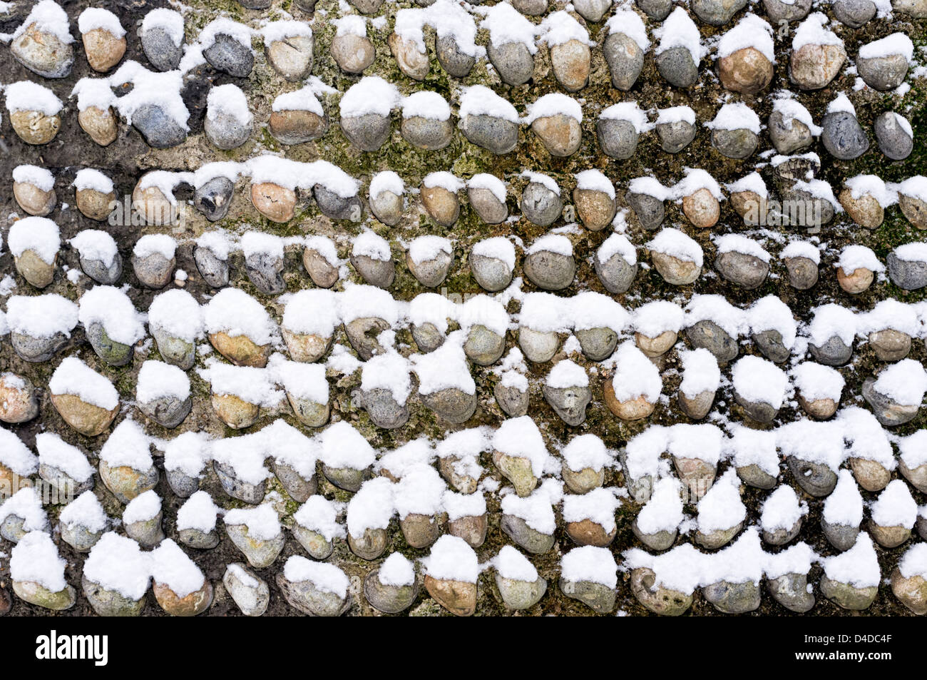 Snow caught on the face of a cobblestone wall Stock Photo - Alamy