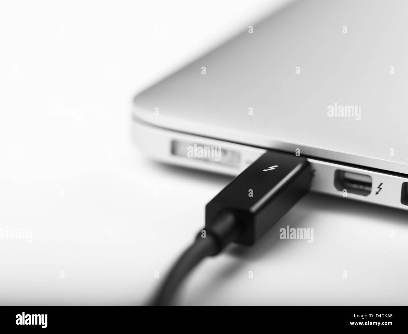 LONDON-JAN.01: photo studio of a thunderbolt cable linked to a laptop ...