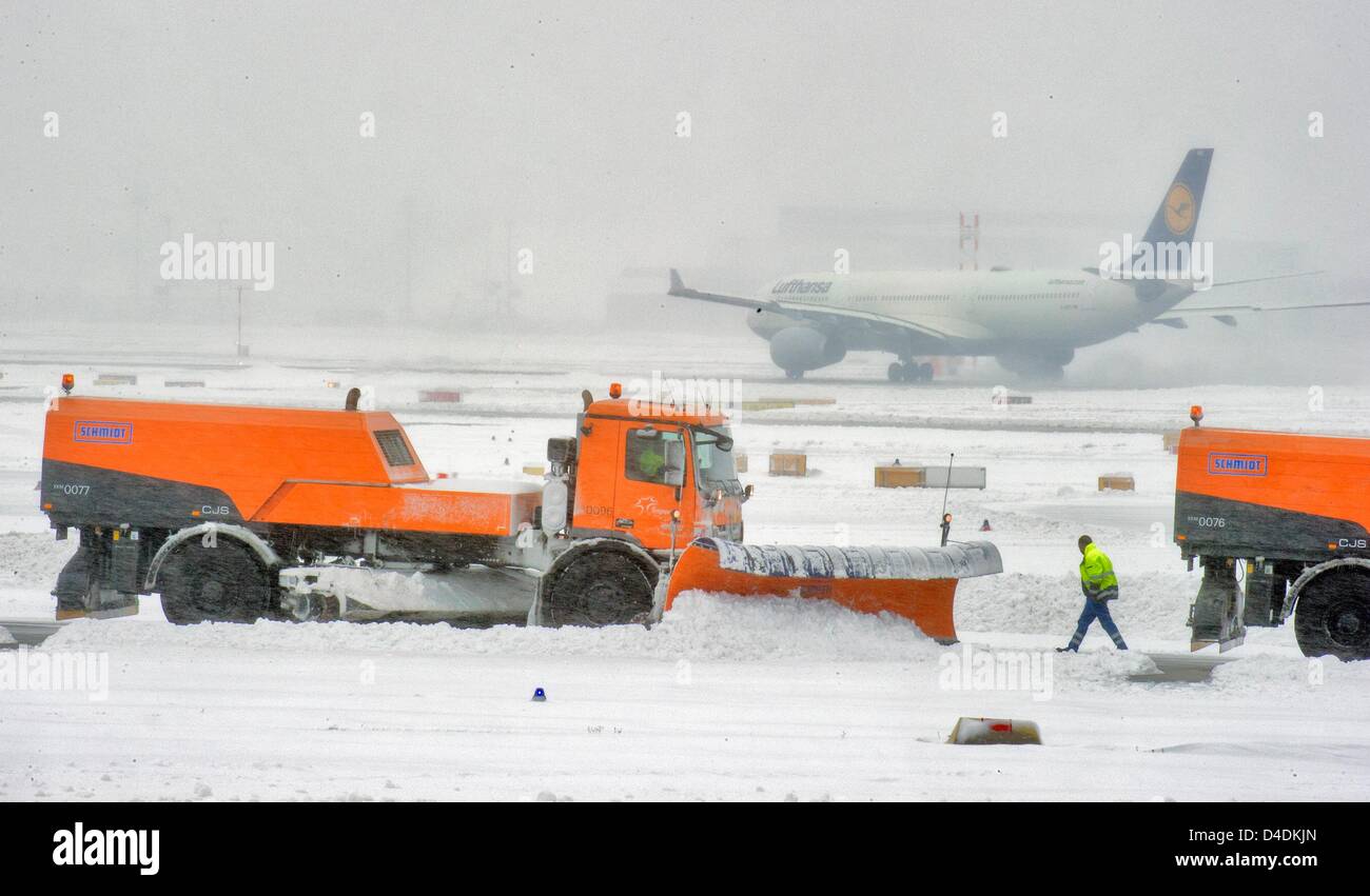 Snow ploughs remove snow from the airfield at the snow-covered ...