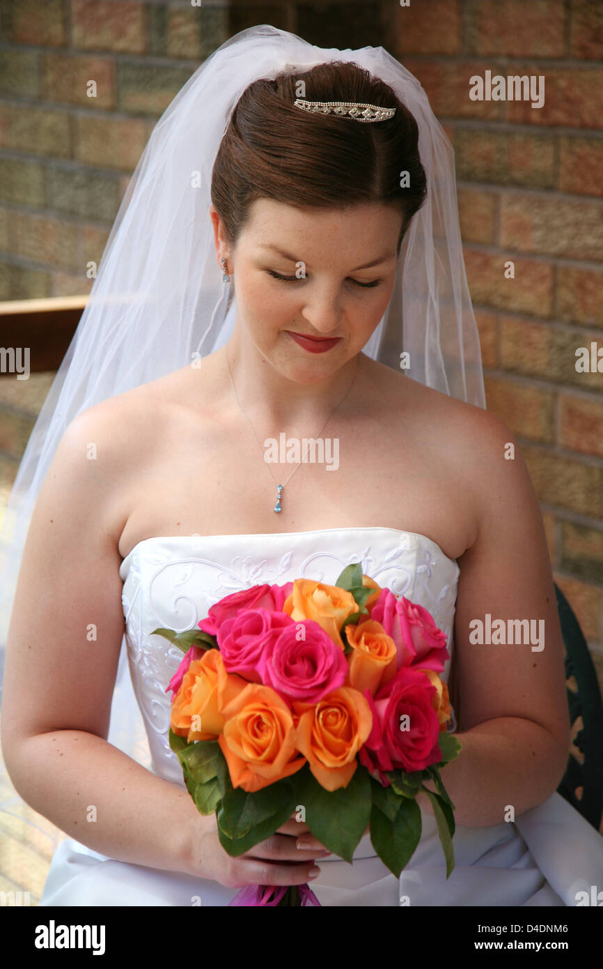 A Beautiful Bride is looking down at her Bouquet Stock Photo - Alamy