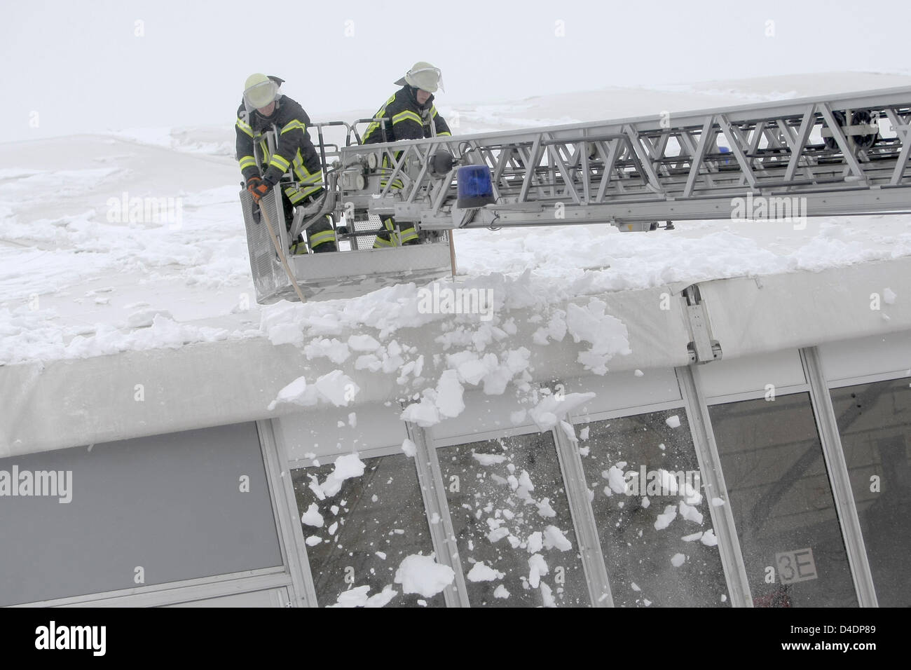 Firemen free snow from the roof of a large tent in Mainz, Germany, 12 ...
