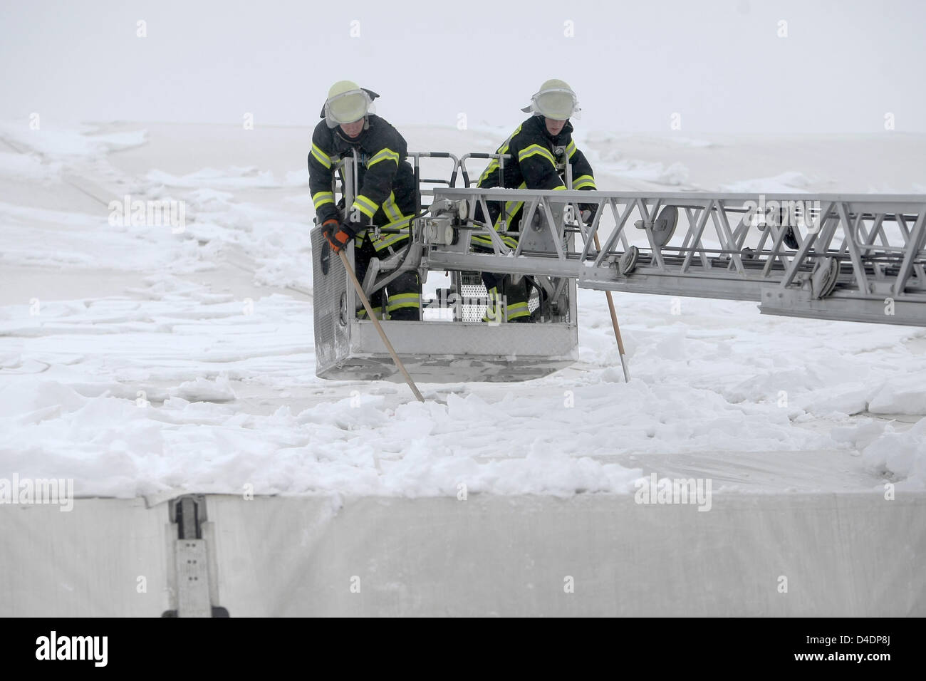 Firemen free snow from the roof of a large tent in Mainz, Germany, 12 ...