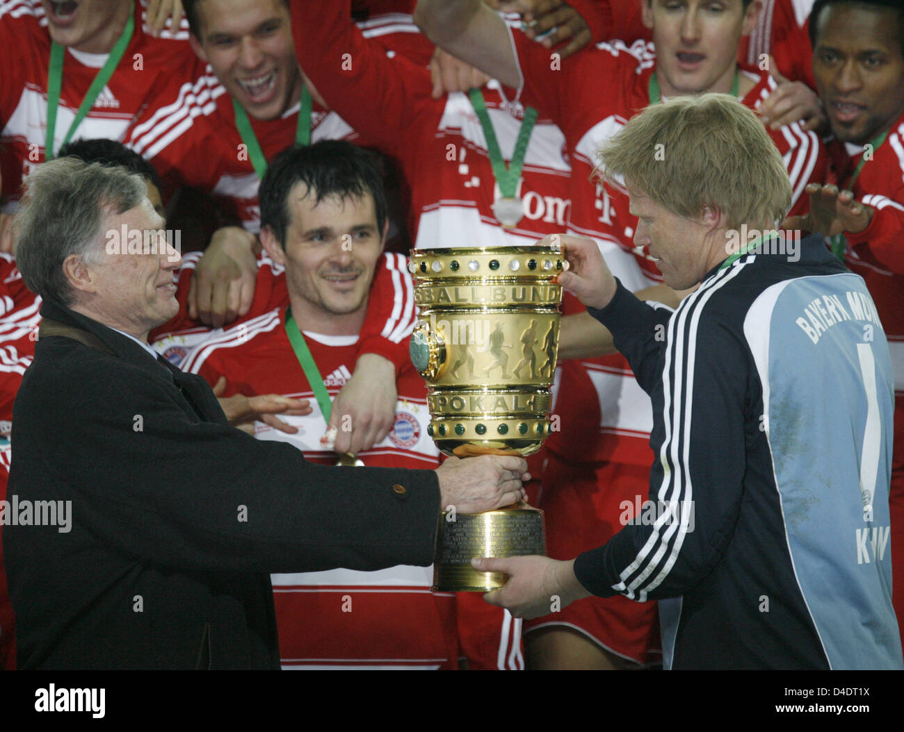 Bayern Munich's goalkeeper Oliver Kahn (R) receives the trophy from ...