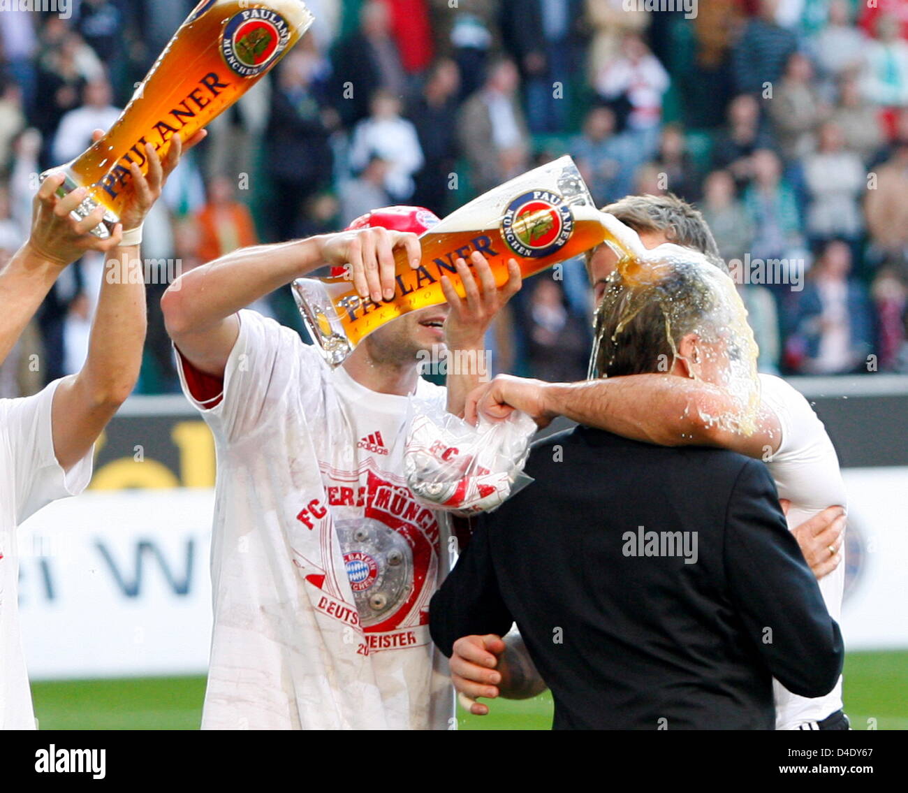 Munich's coach Ottmar Hitzfeld (R) is doused with beer after winning ...