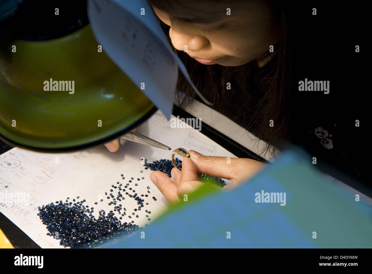 Staff of a jewellery manufactory sets sapphires into the correspondent ...