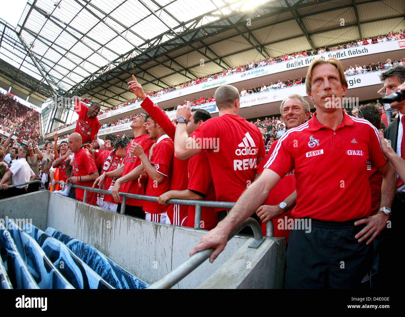 Cologne's head coach Christoph Daum (R) stays cool while team and fans ...