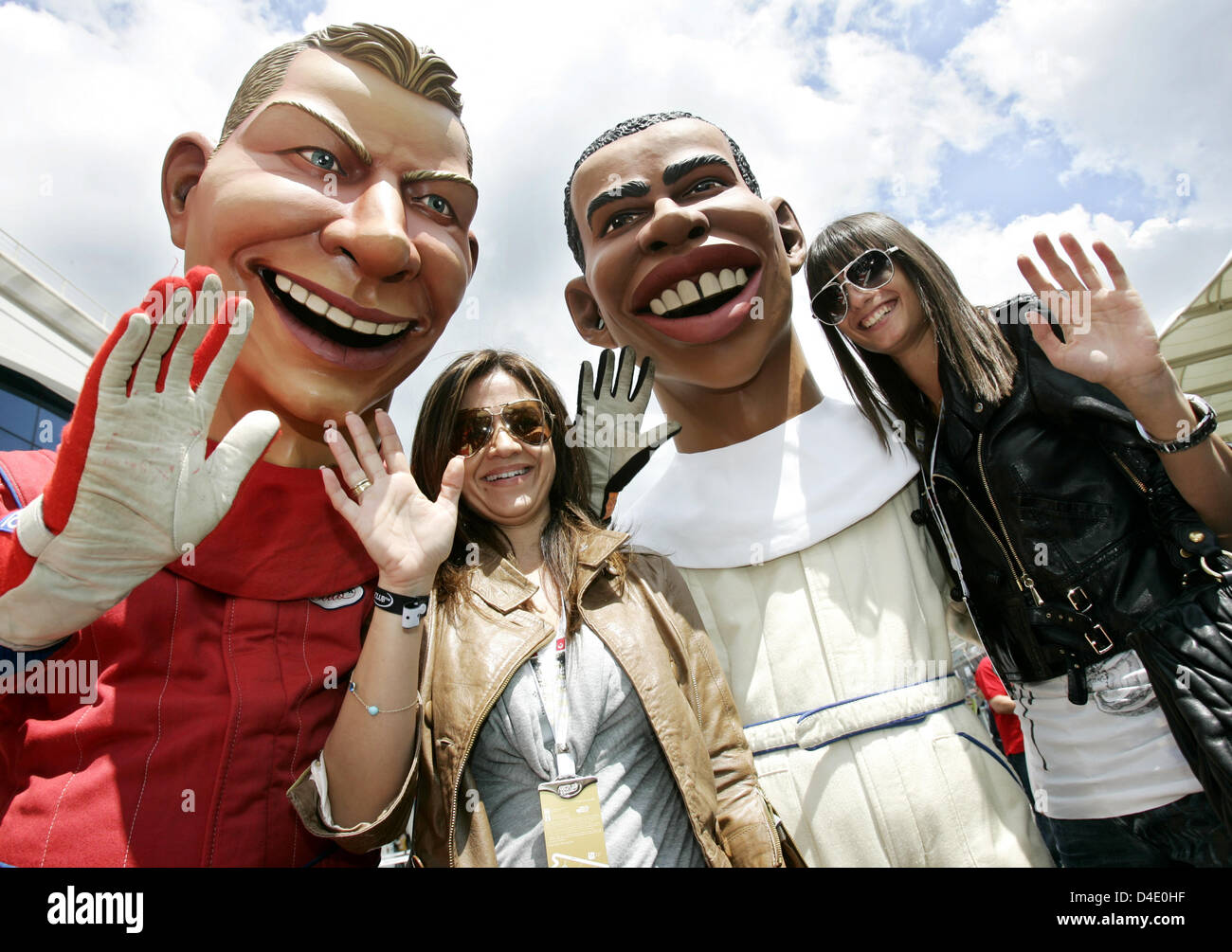 Female Formula One fans pose with two puppets of Ferrari's Kimi ...