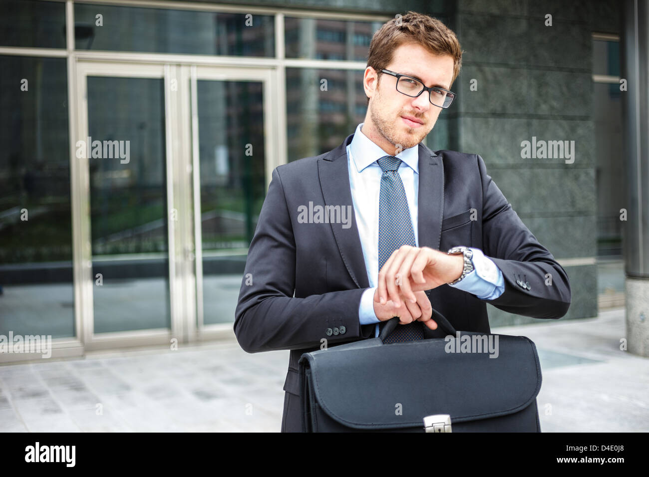 Handsome businessman checking time on his watch Stock Photo - Alamy