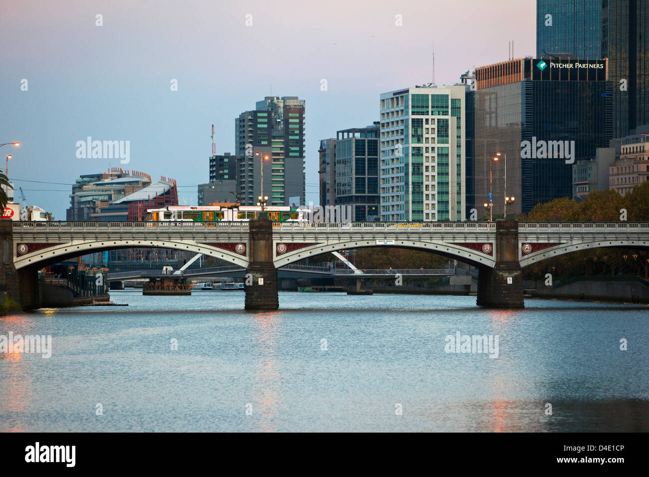 Tram crossing the Princess Bridge over Yarra River, with city skyline ...