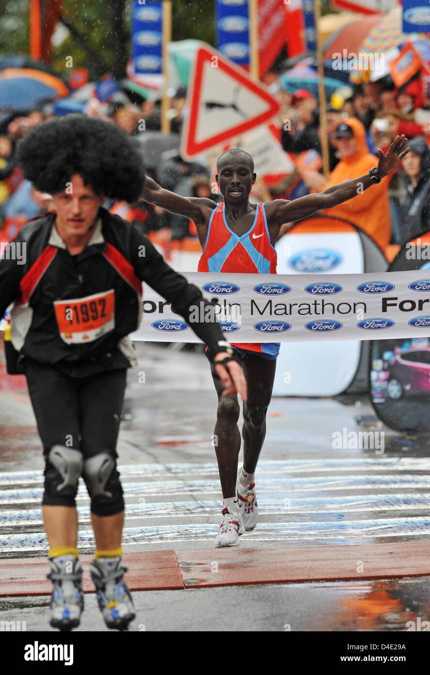 Kenian Sammy Kurgat (R) arrives at the marathon's finish line in ...