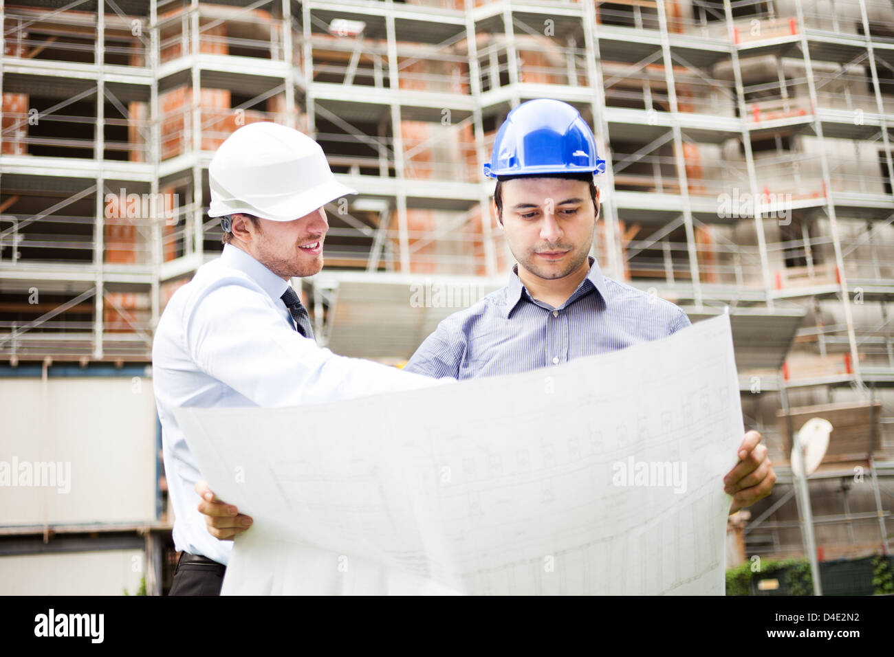 Architect explaining a drawing to the foreman Stock Photo - Alamy