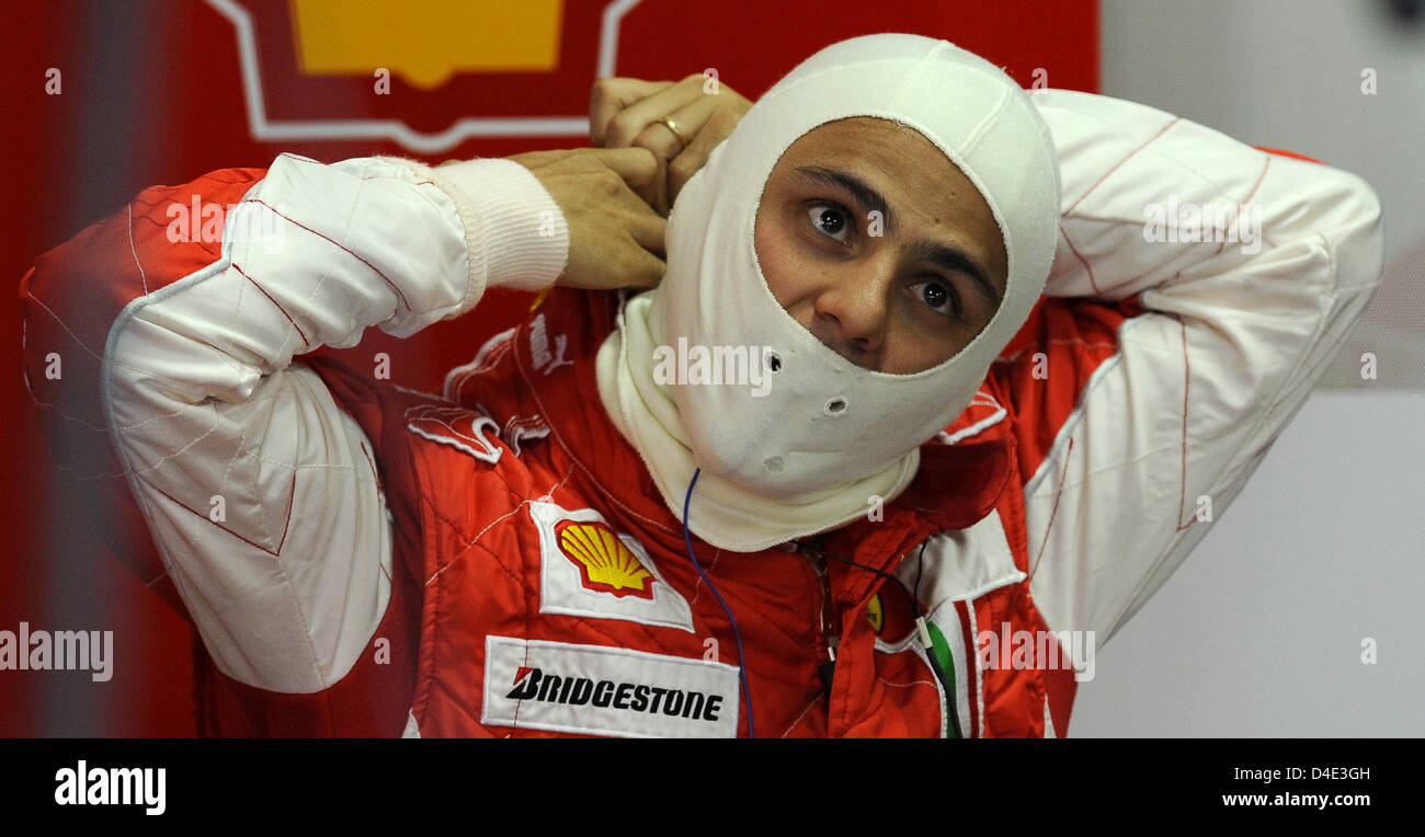 Brazilian Formula One driver Felipe Massa of Ferrari lputs on his ...