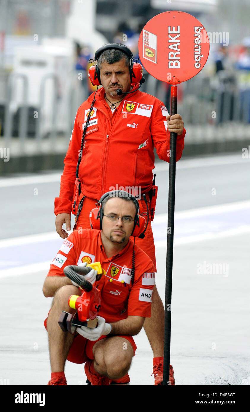 Mechanics of Ferrari wait with the lollipop in the pit lane during the ...