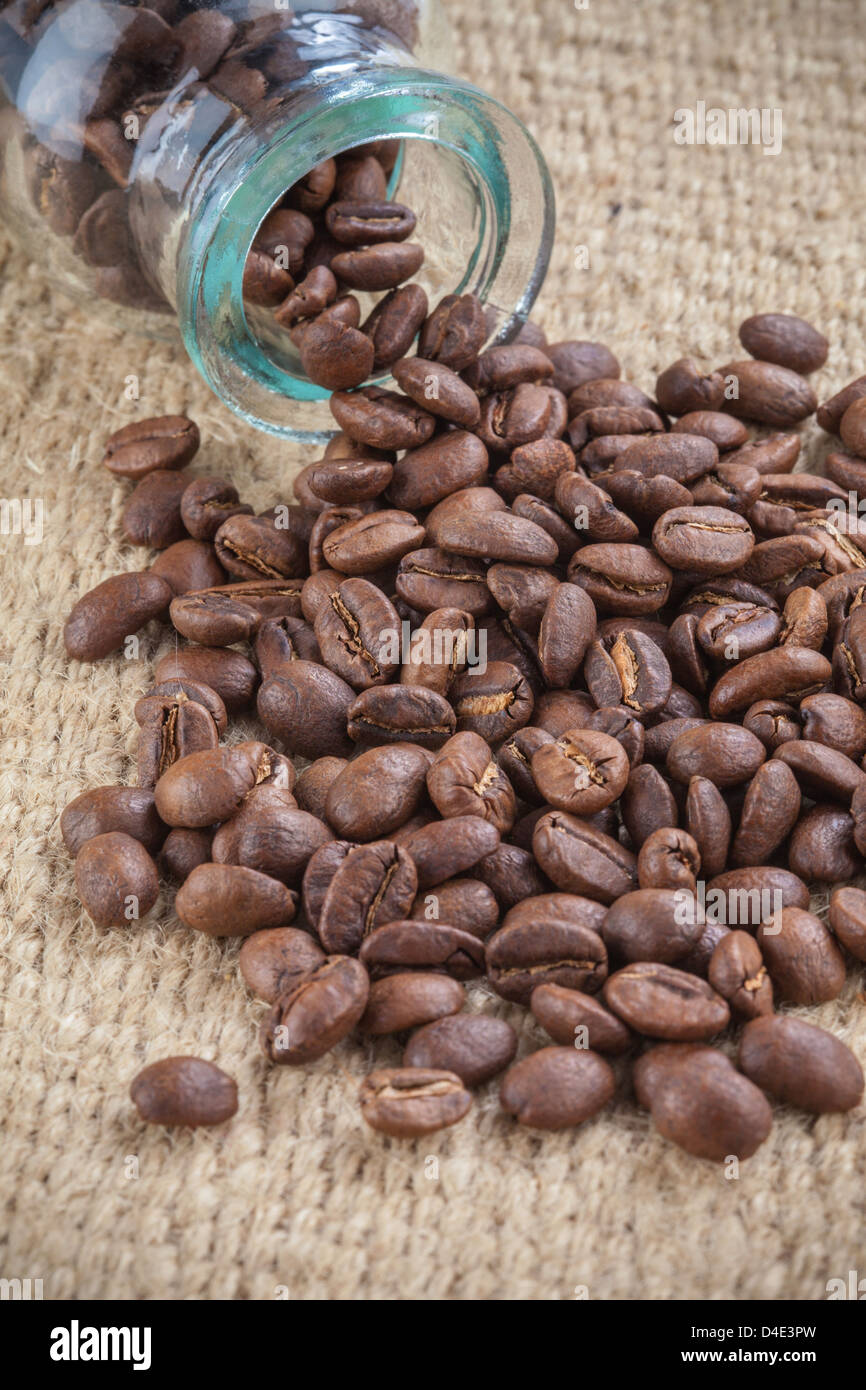 Coffee beans spilled out from glass little jar Stock Photo - Alamy