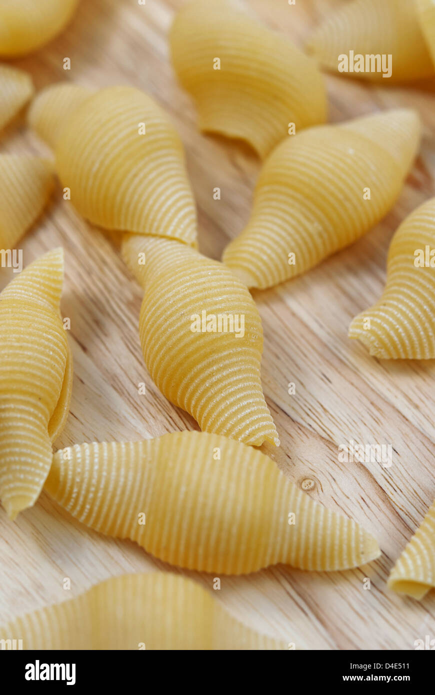 Big pasta shells or conchiglioni on the wooden table Stock Photo - Alamy