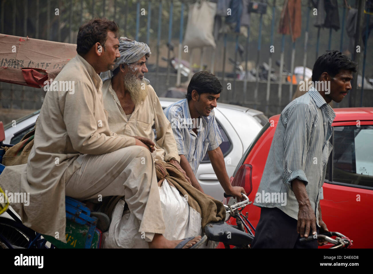 Two men riding on the back of a rickshaw in Shahjahanabad, Chandni ...