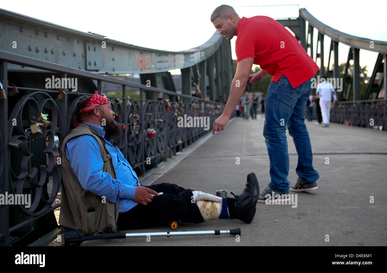 Young man giving change to an old homeless man sitting on the floor on ...
