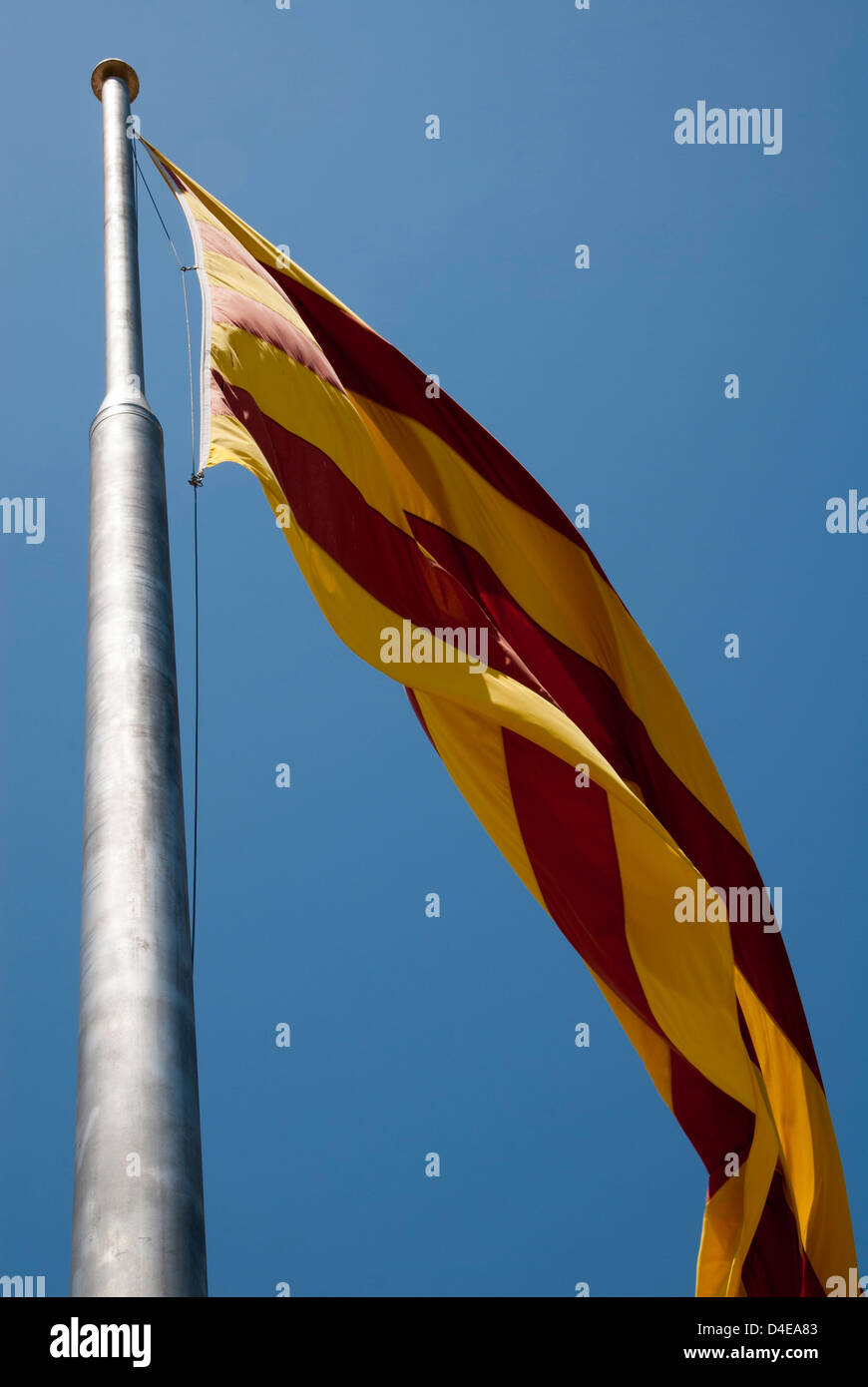 Waving flag of the Catalunya (Catalonia) on background of the blue sky ...