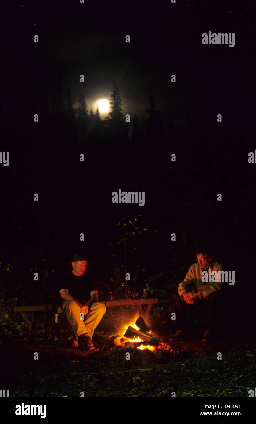 Two steelhead anglers warming around a campfire on the Babine River ...