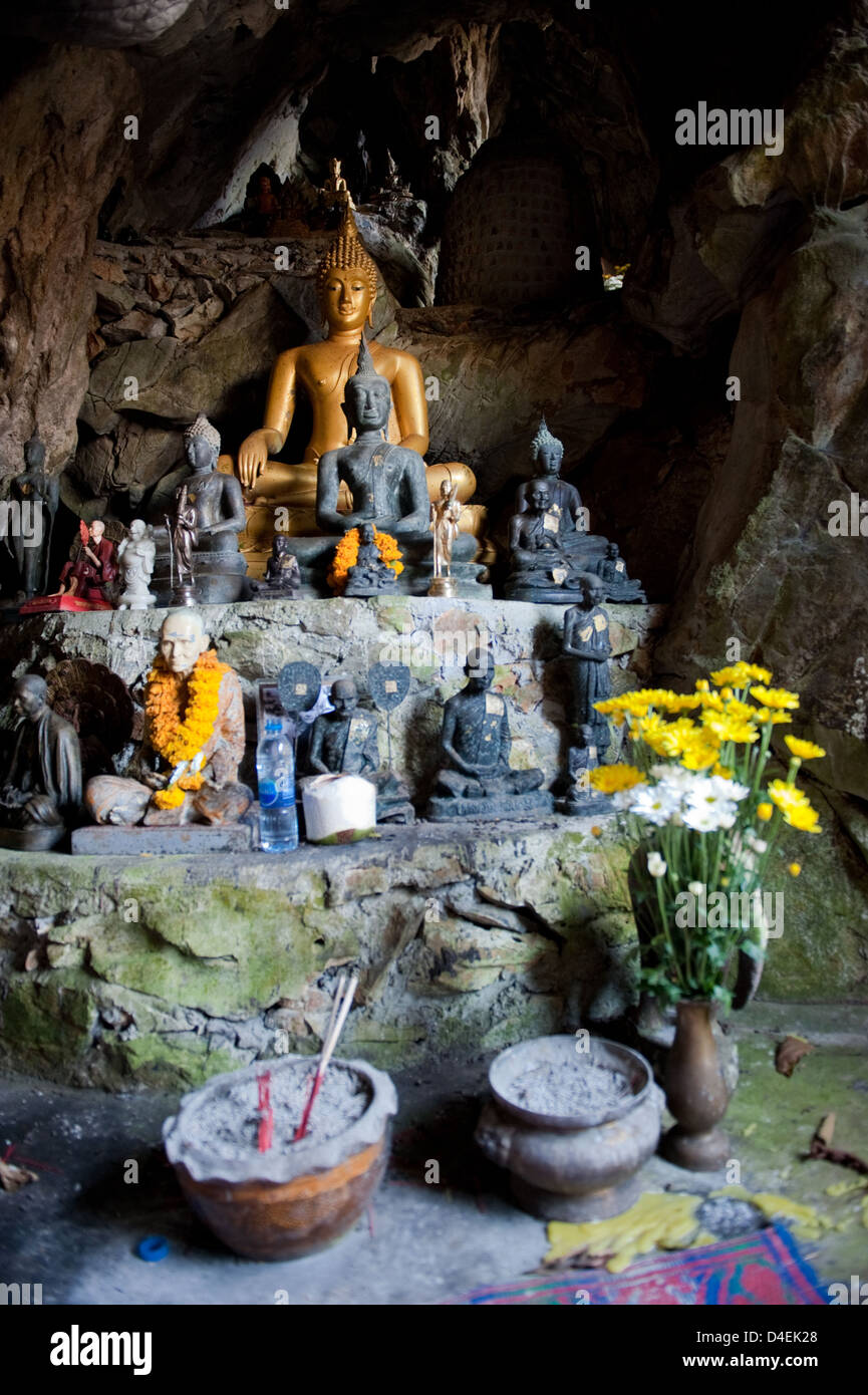 Mae Sai, Thailand, seated Buddha statues in a cave with offerings Stock ...