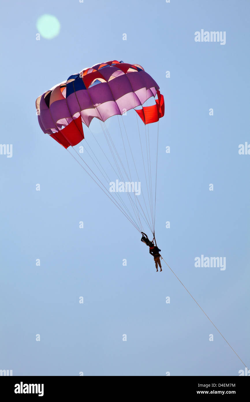 vertical portrait of a couple paragliding in a clear blue sky and ...