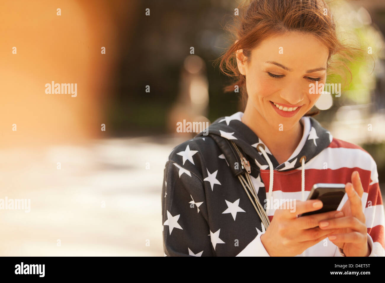 Woman using cell phone on city street Stock Photo - Alamy