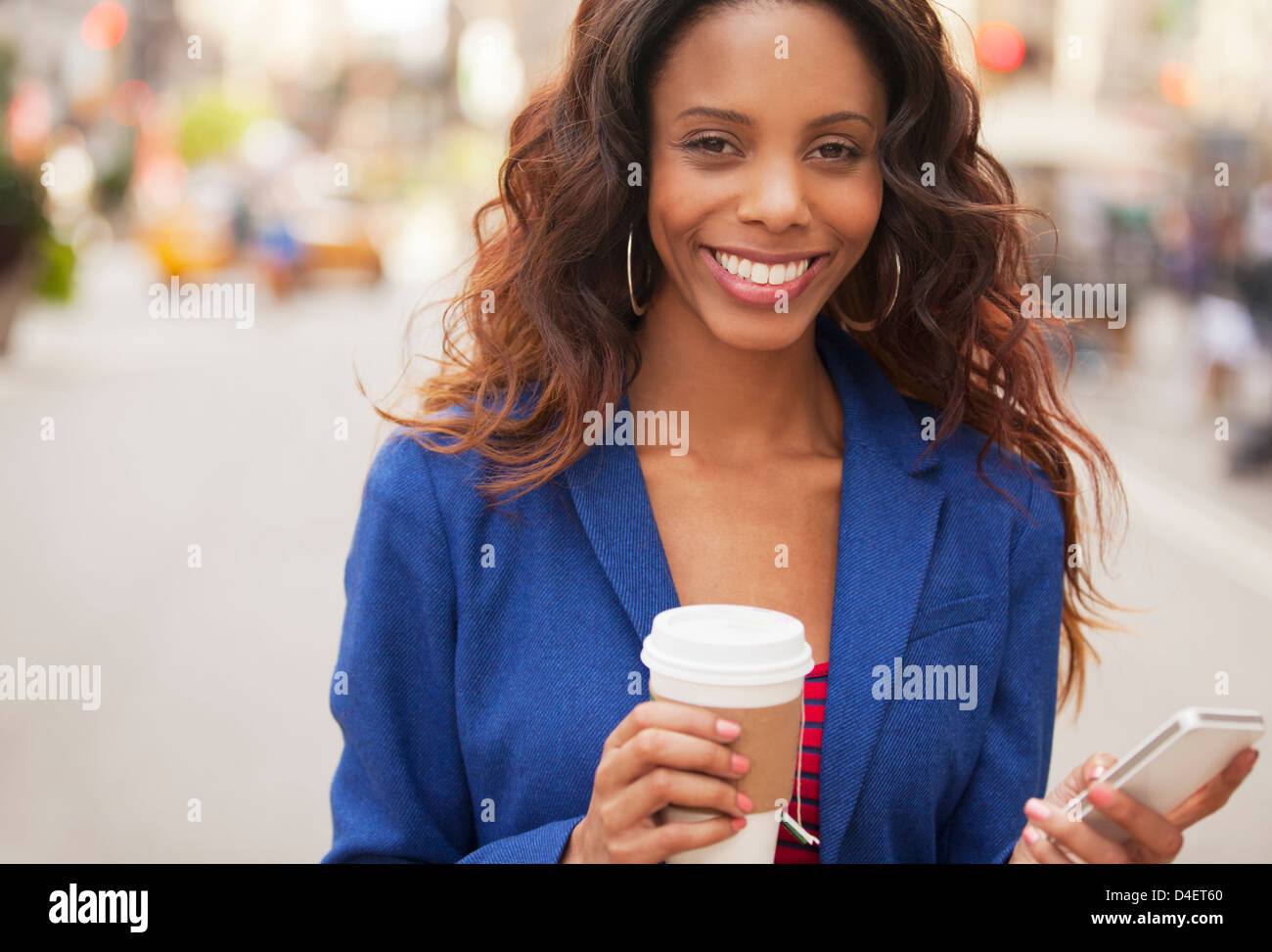 Woman using cell phone on city street Stock Photo - Alamy