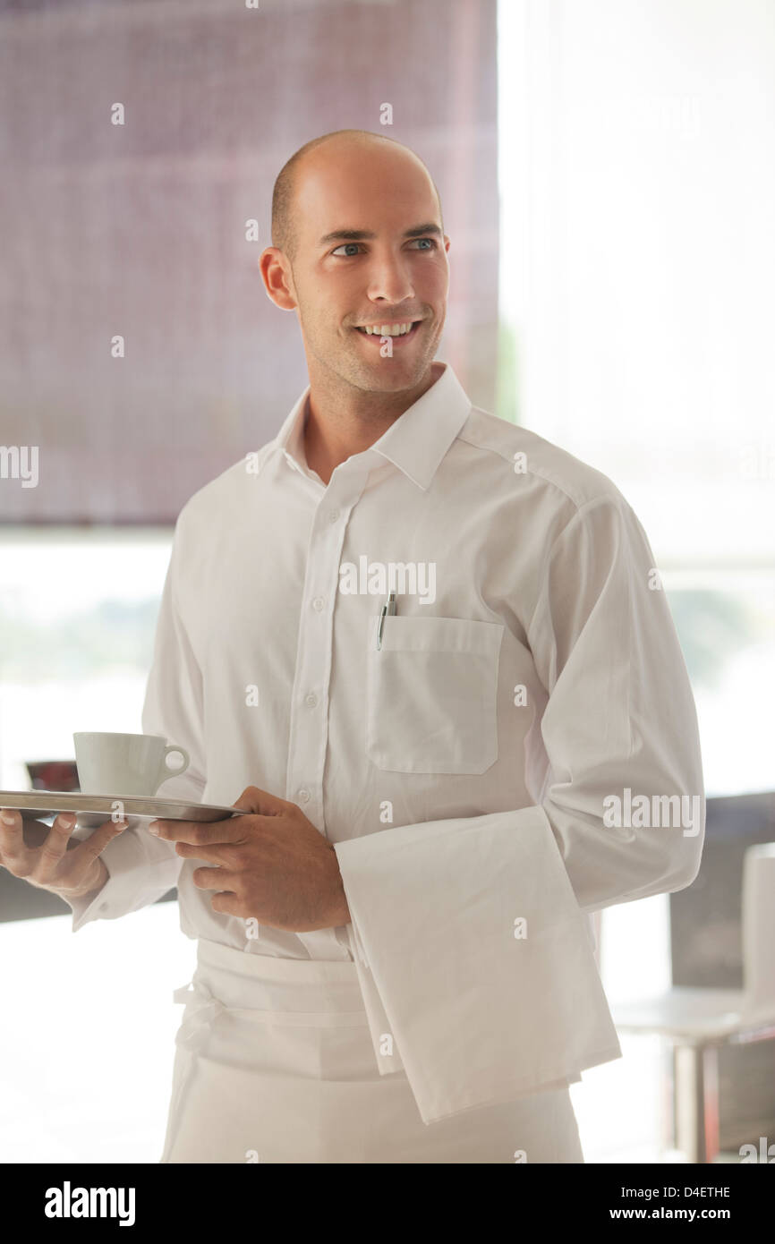 Waiter carrying cup of coffee in restaurant Stock Photo - Alamy