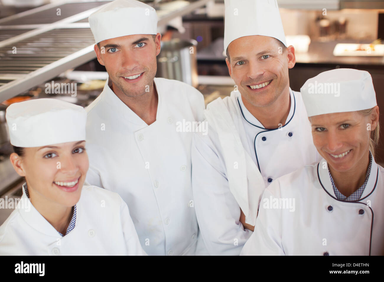 Chefs smiling in restaurant kitchen Stock Photo - Alamy