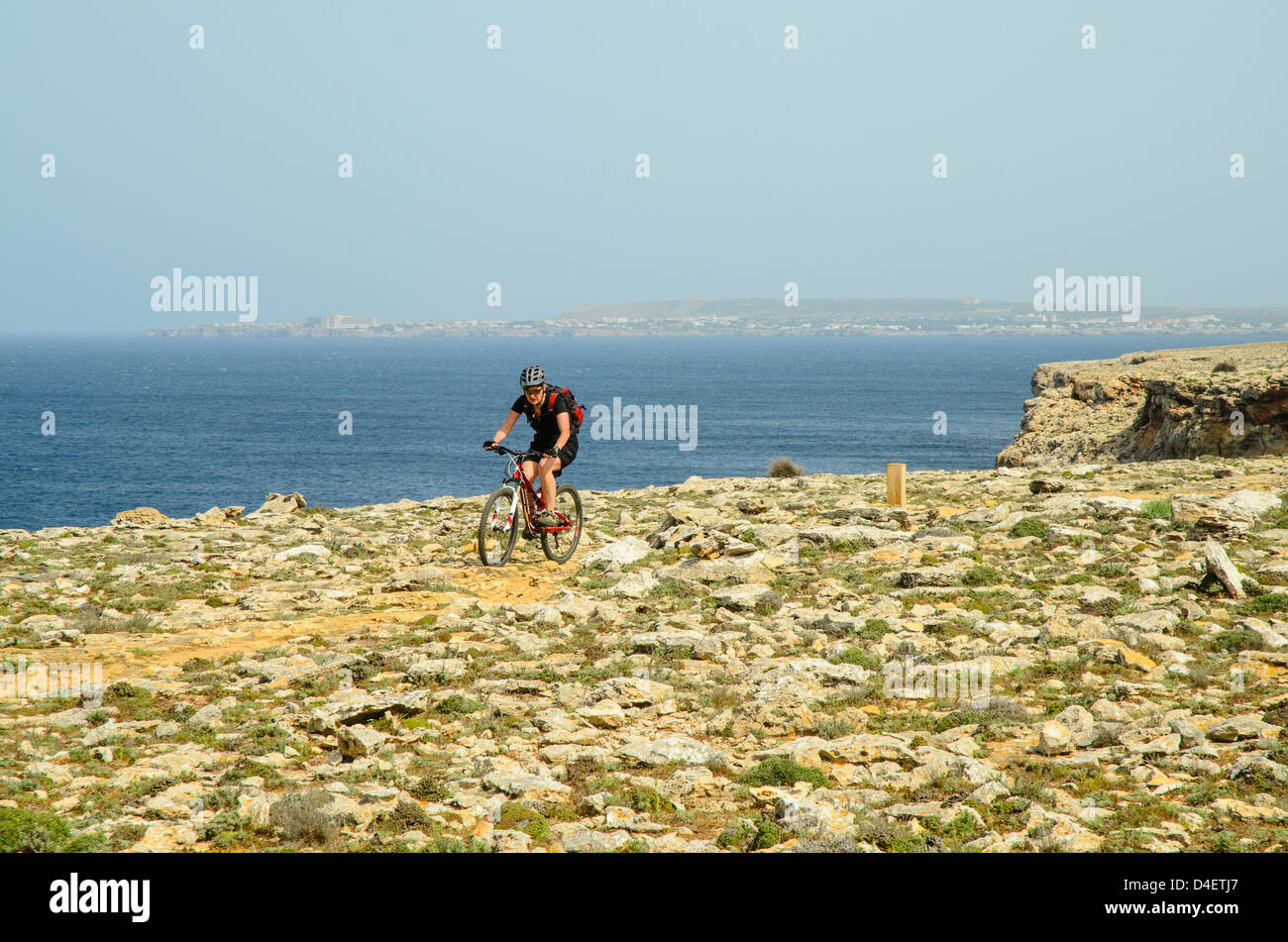 Mountain biker on the Cami de Cavalls coastal path near Ciutadella on ...